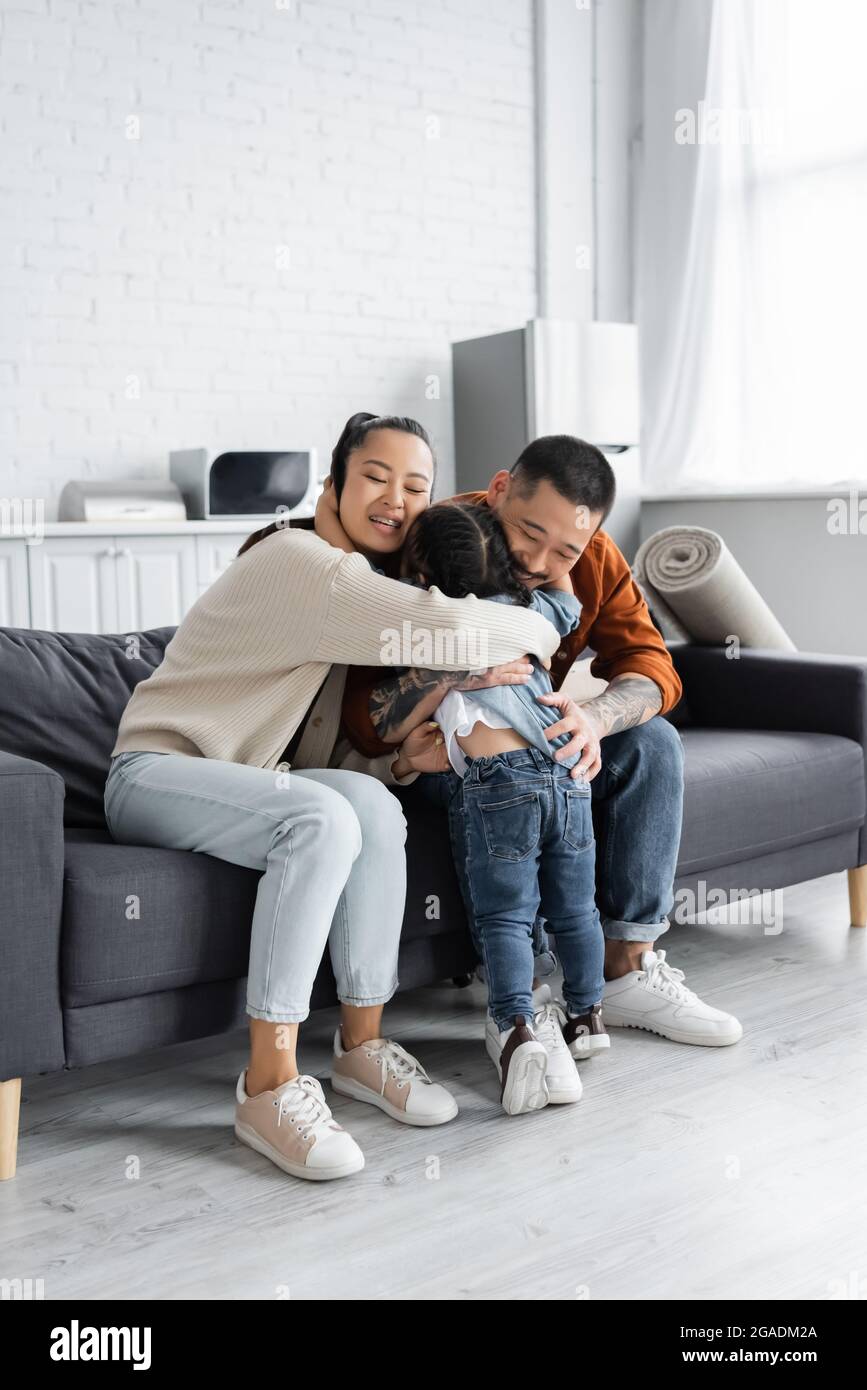 happy asian family hugging in modern living room Stock Photo - Alamy