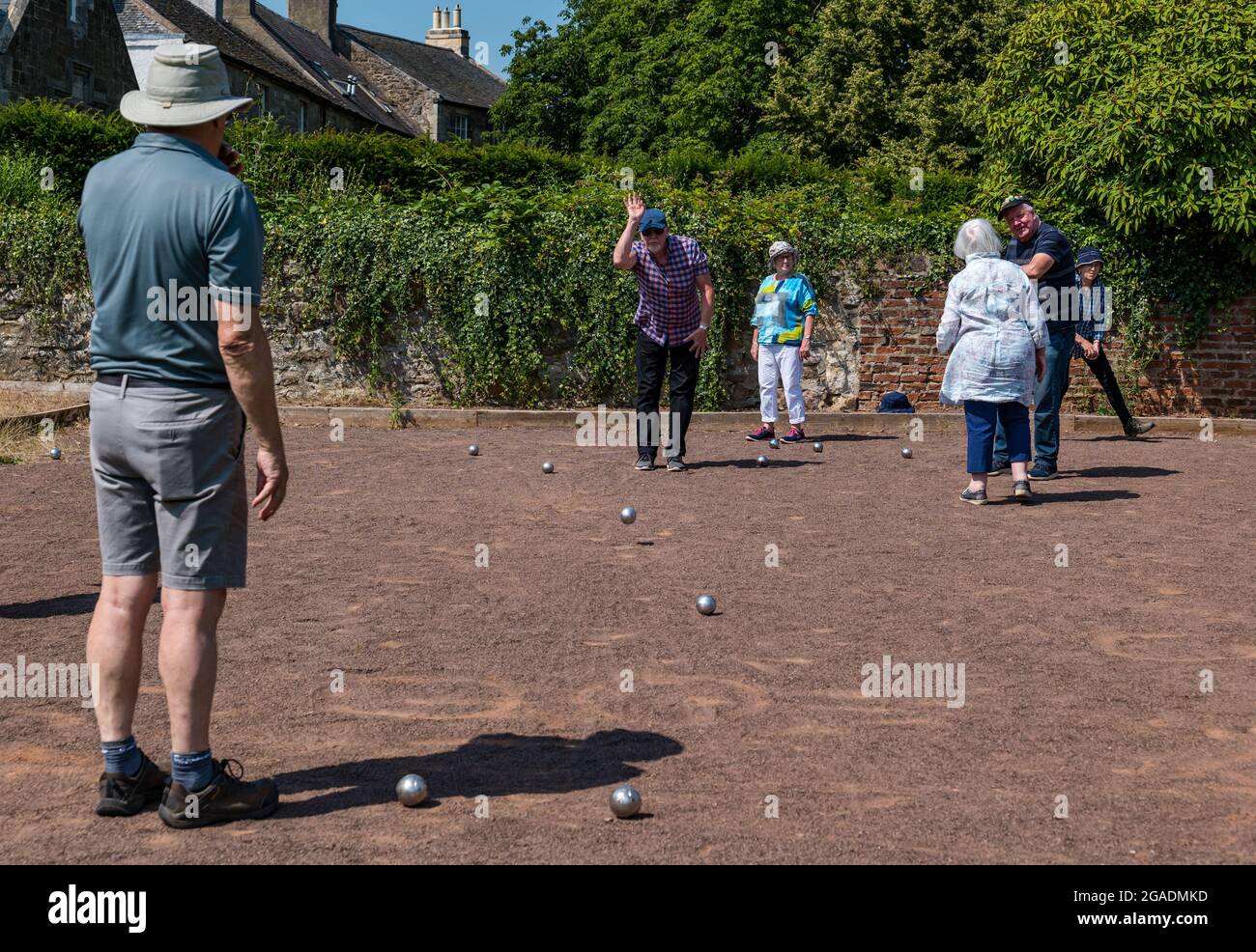 Senior citizens, older people or pensioners playing petanque or boules ...