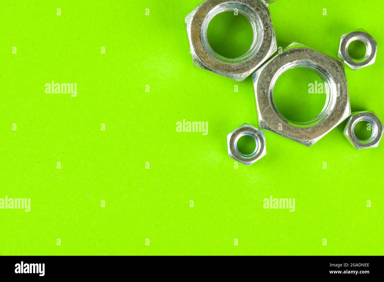 Engineering tools. Bolts and nuts on green background Stock Photo - Alamy