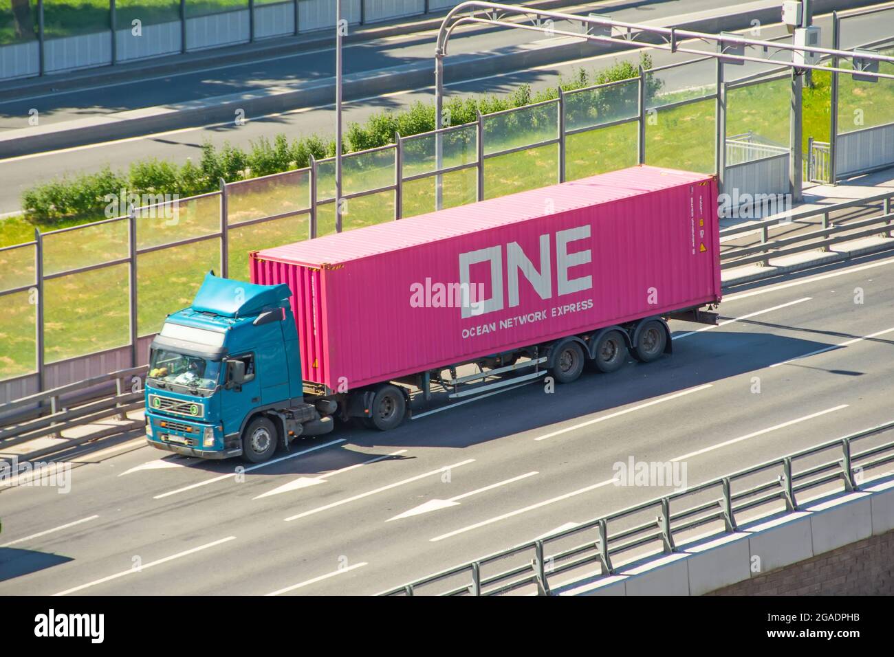 ONE Ocean Network Express shipping containers travel by truck with long trailer platform on the ...