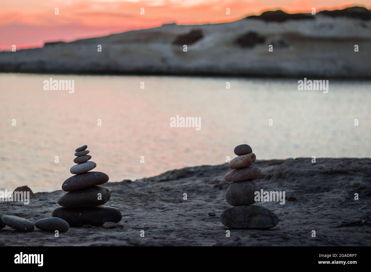 Pyramid stones balance on the sand of the beach. The object is in focus ...