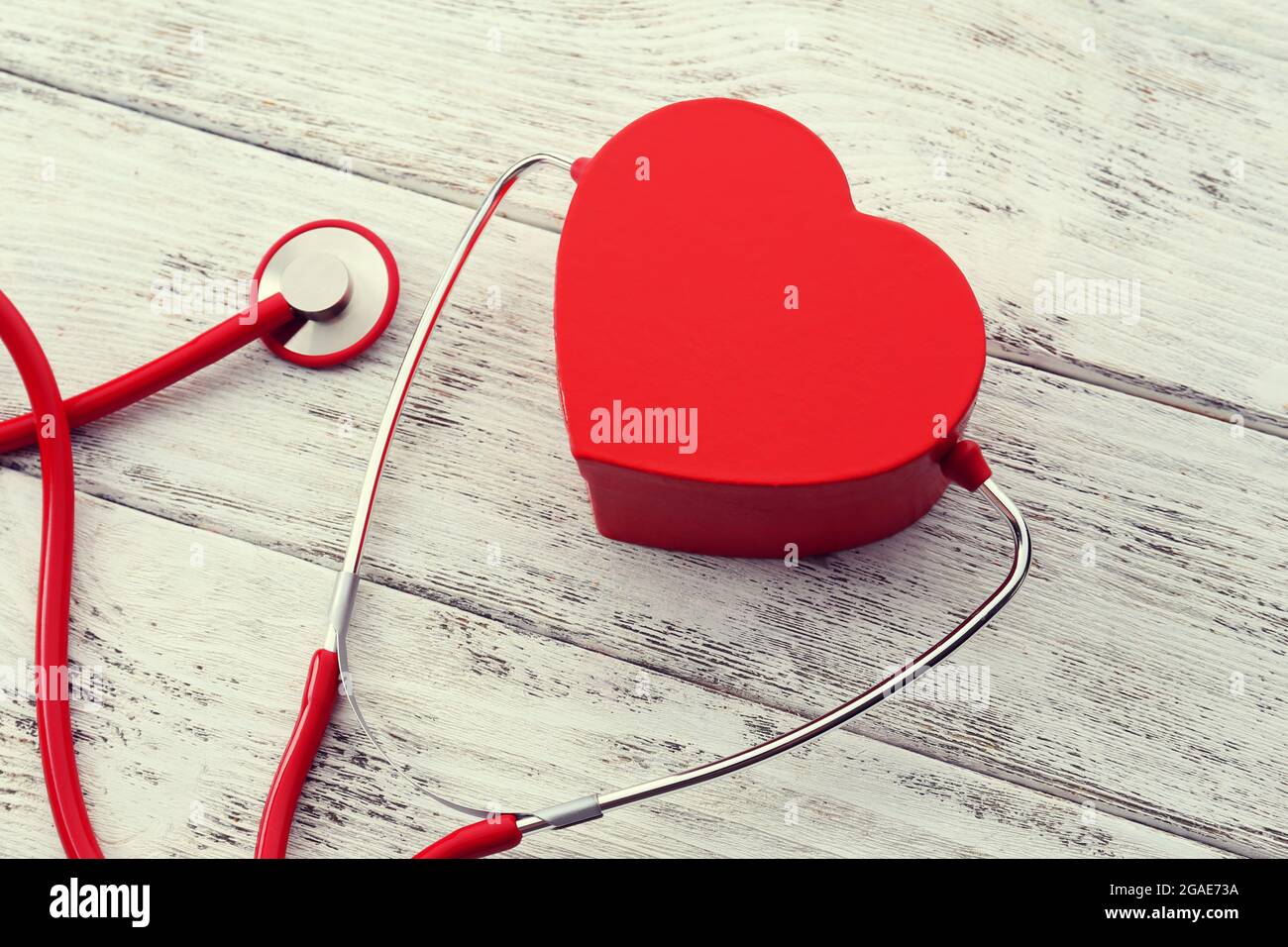 red stethoscope with heart on bright wooden background Stock Photo - Alamy