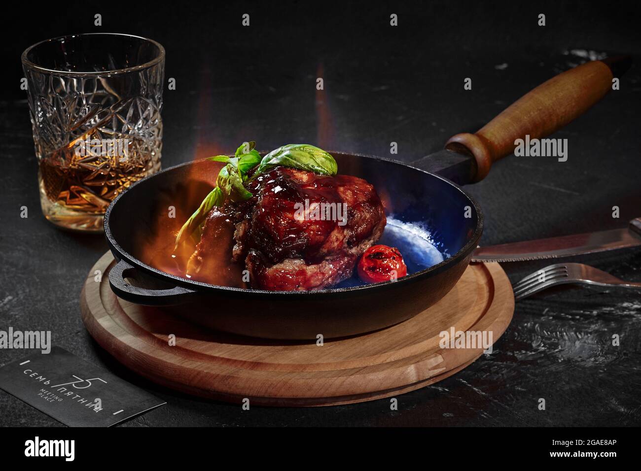 Baked pork meat in barbecue sauce flamed with brandy in skillet Stock ...