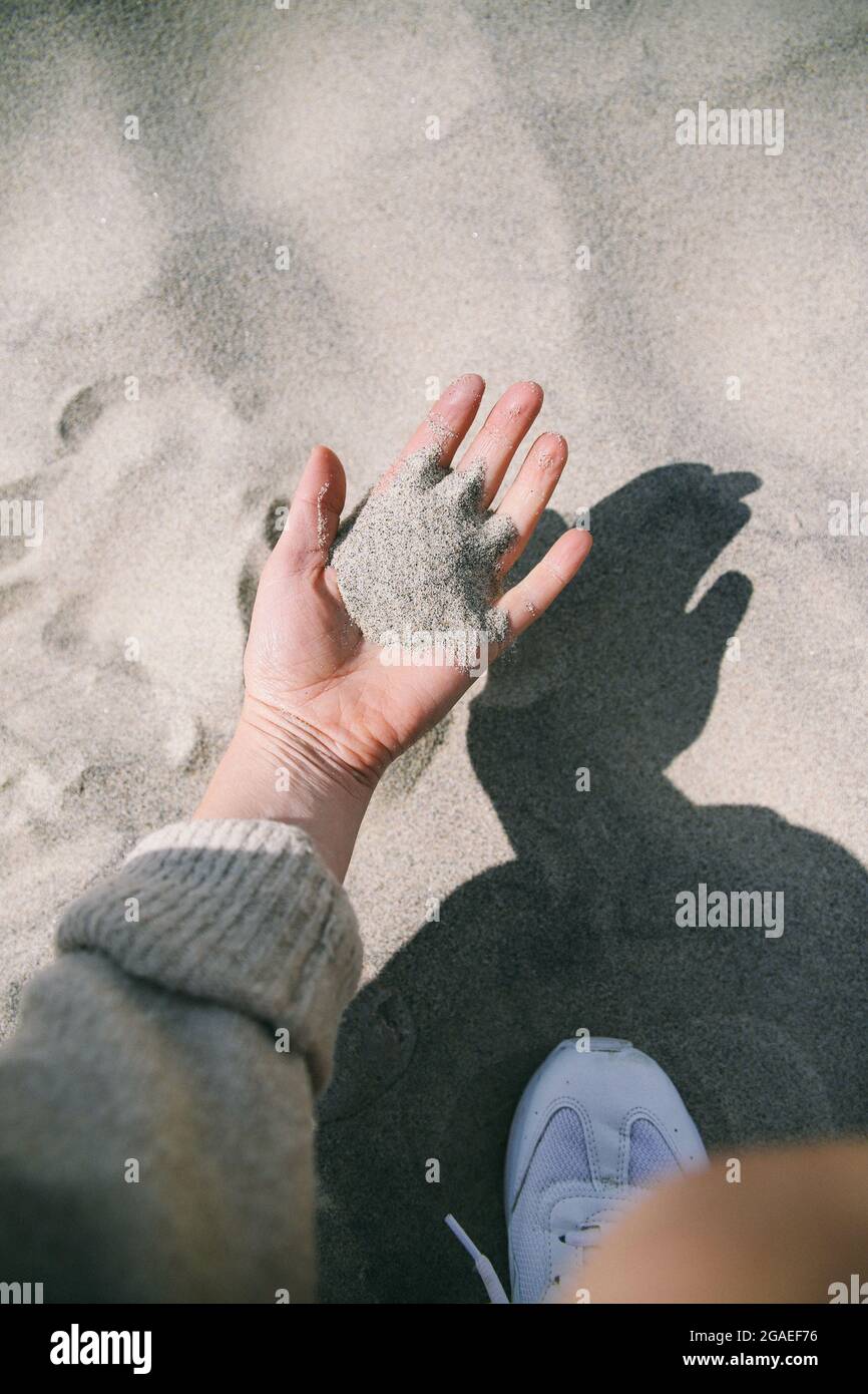 Hand full of send on the beach on a sunny day Stock Photo - Alamy