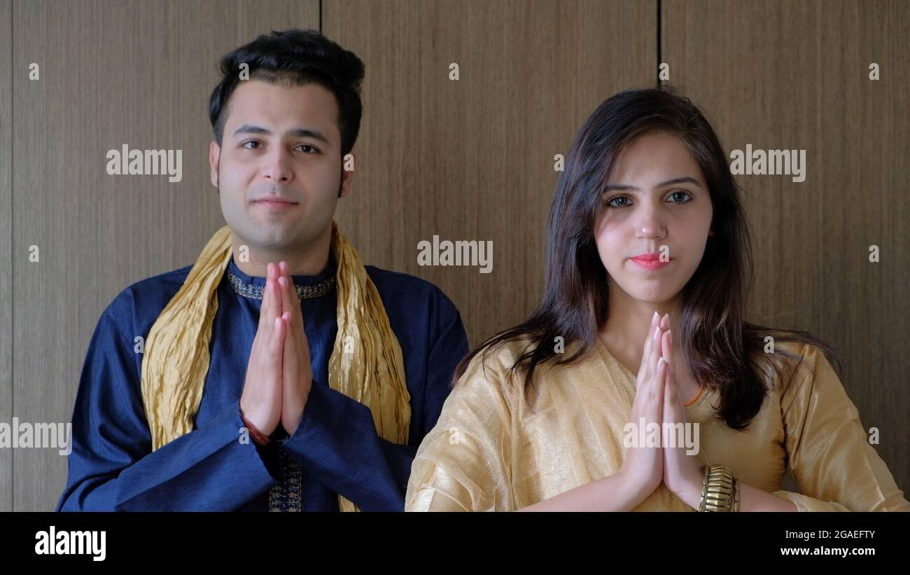 Young Indian couple with their hands in namaste gesture Stock Photo - Alamy