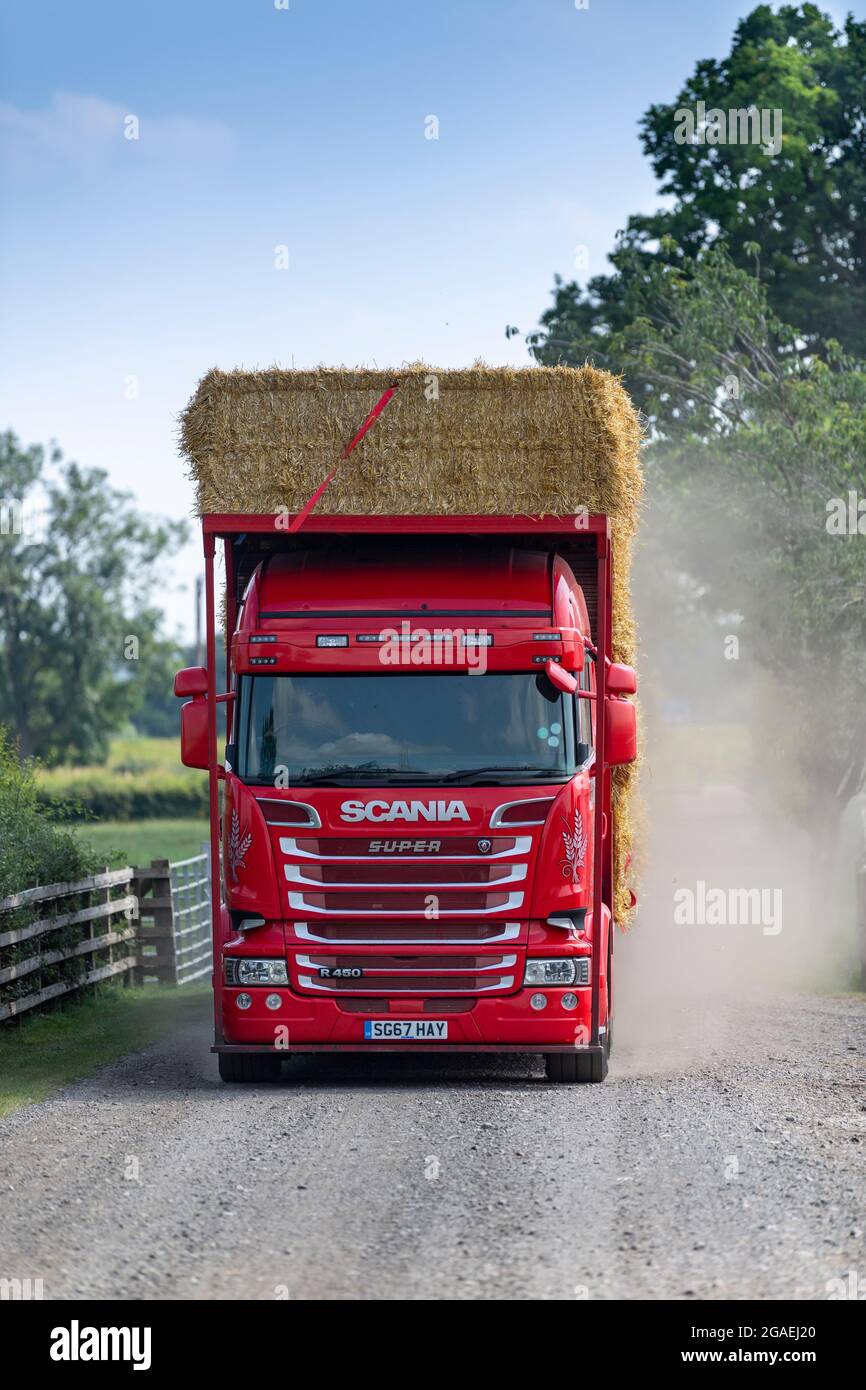 Lorry with load of straw on coming down a dusty farm track, Yorkshire ...