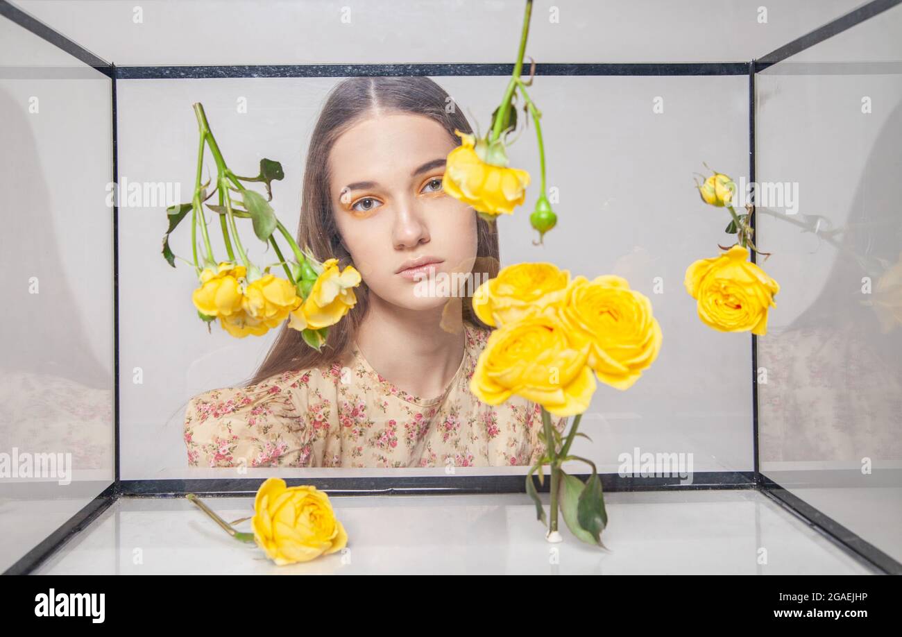 Female model behind glass box with flowers Stock Photo - Alamy