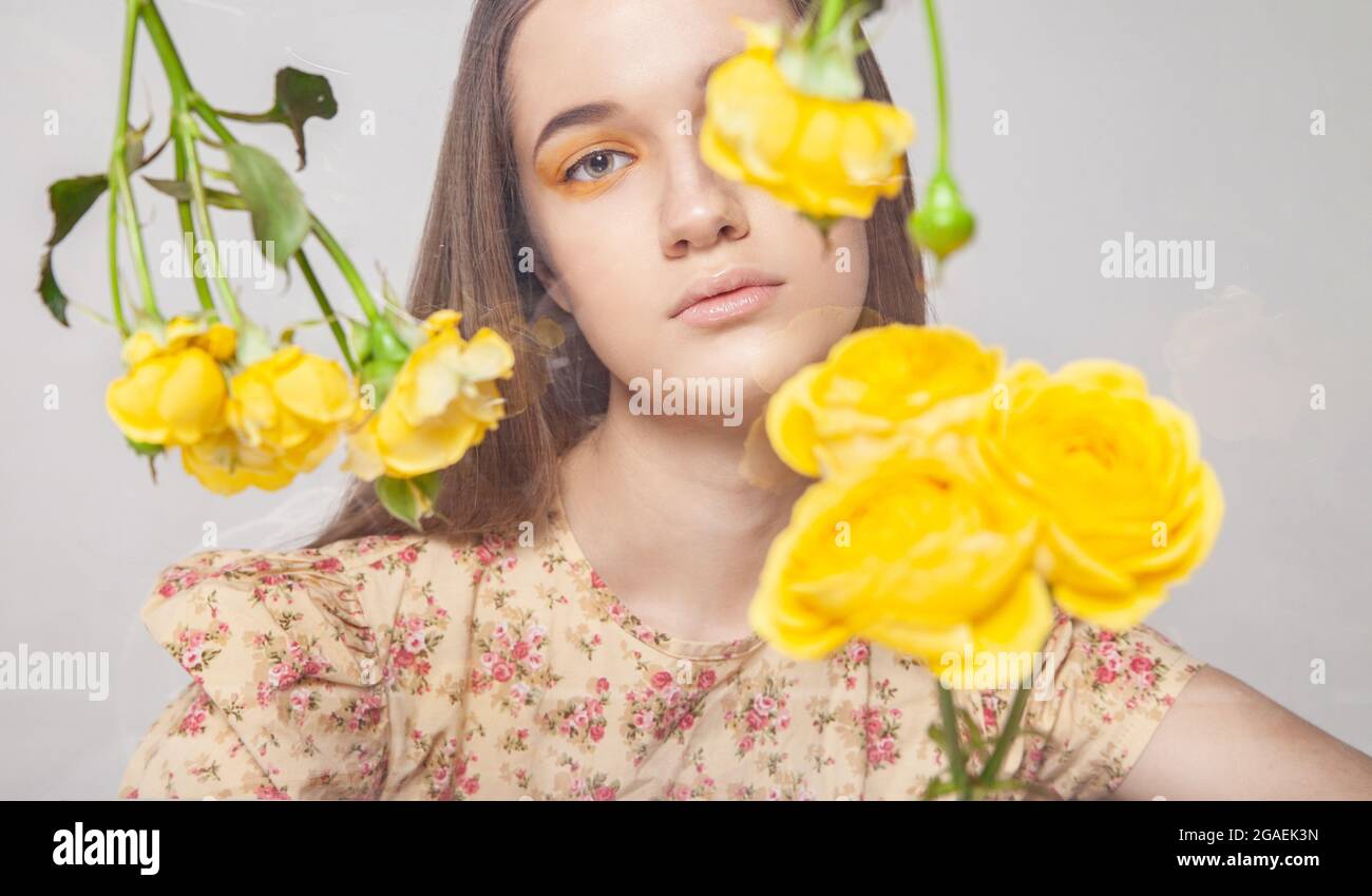 Female model behind glass box with flowers Stock Photo - Alamy