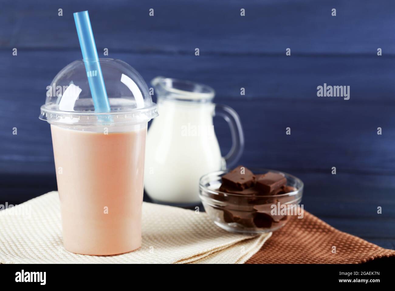 Plastic cup of milkshake on color wooden background Stock Photo - Alamy