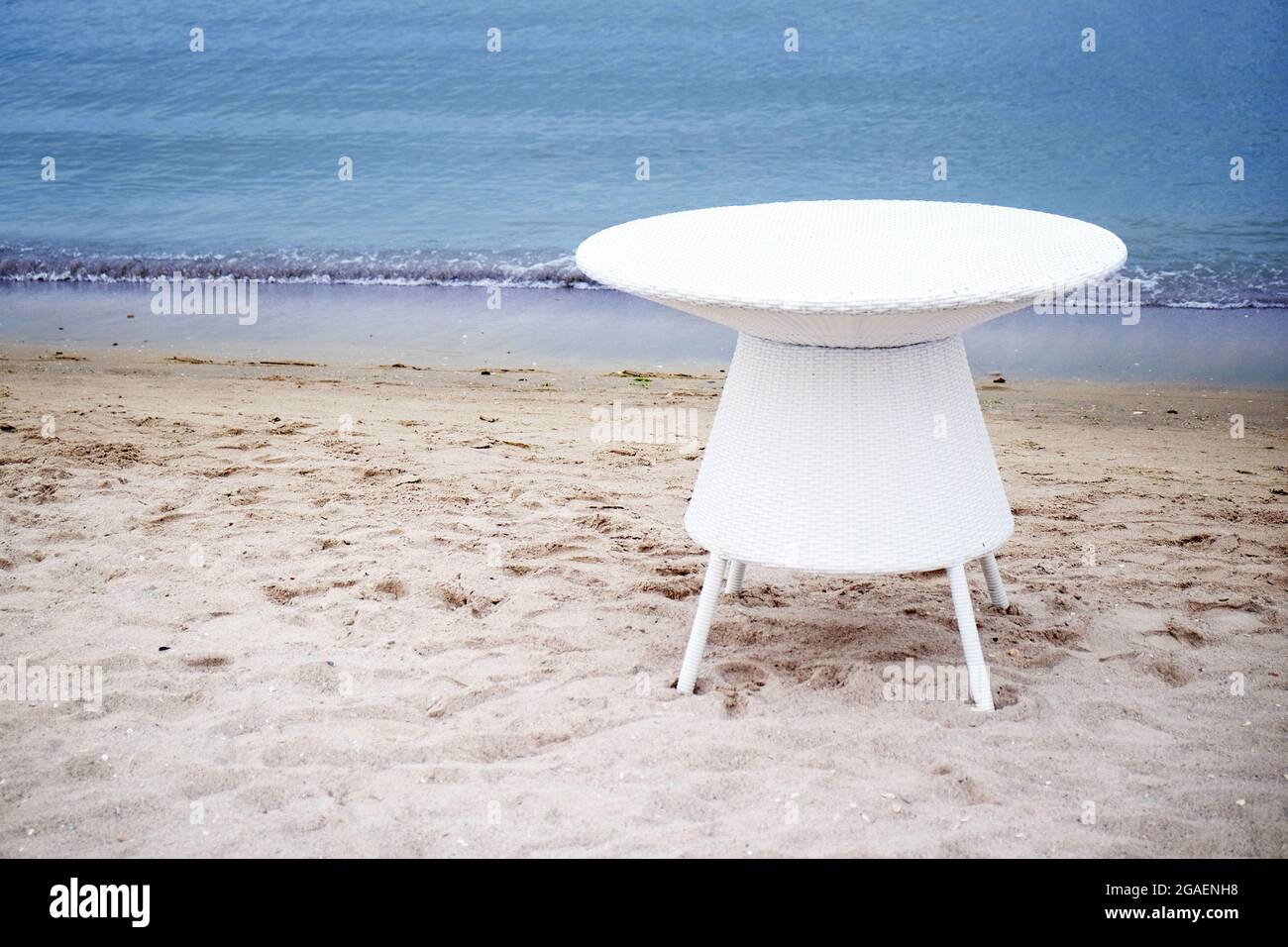 White table on the beach Stock Photo - Alamy