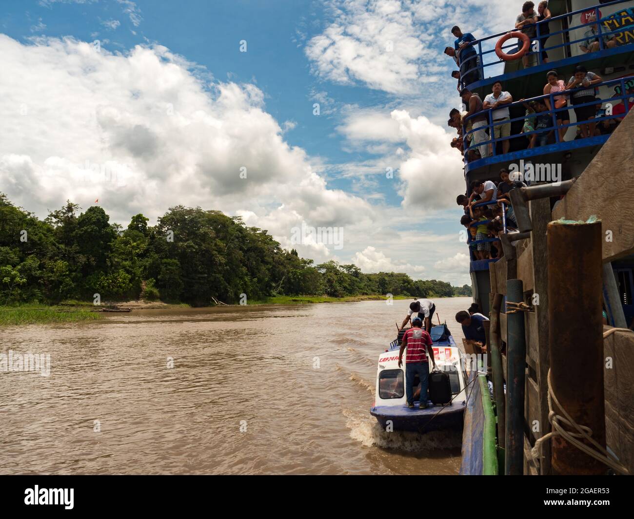 Amazon River, Peru- March, 2018: Small speed boat approaching the big ...