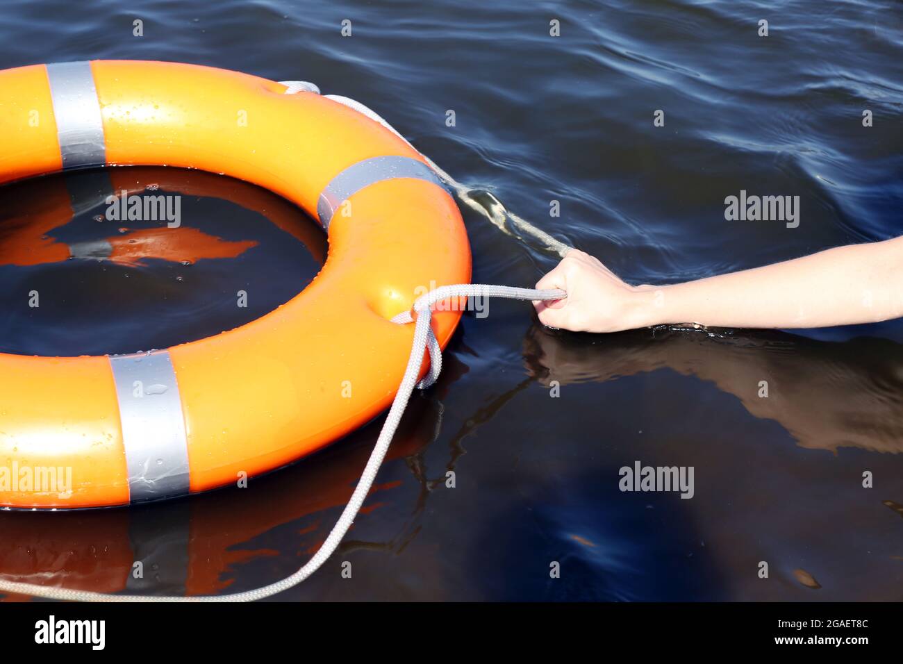 Hand holds a cord of a life buoy Stock Photo - Alamy