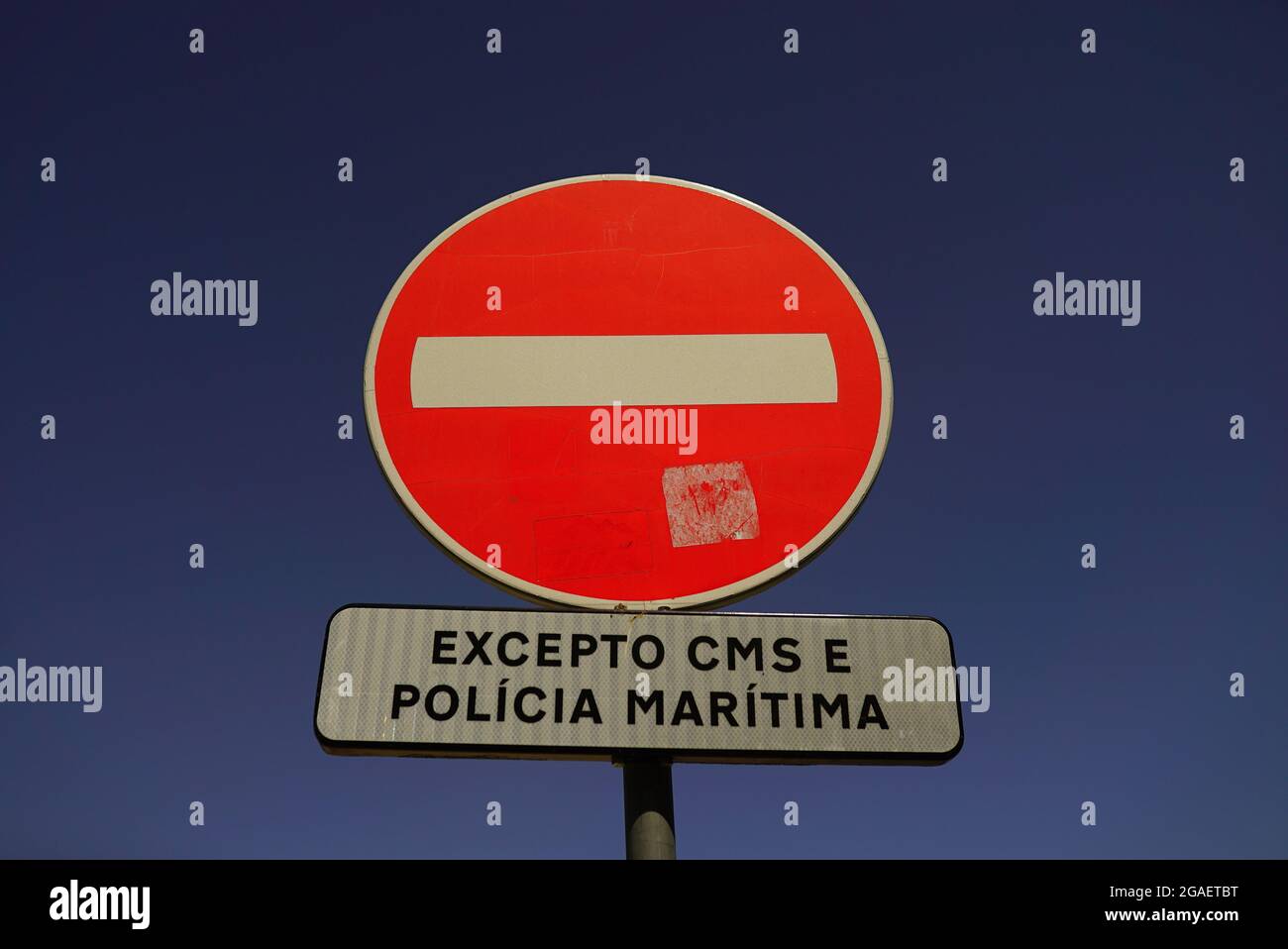 Low-angle shot of a stop sign with the Spanish text "except cms and ...