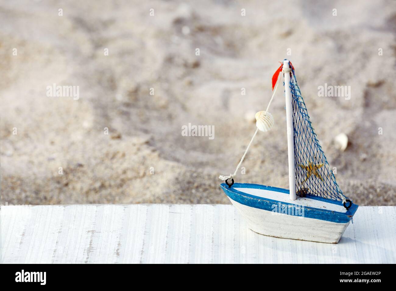 Small ship on sand beach background Stock Photo - Alamy