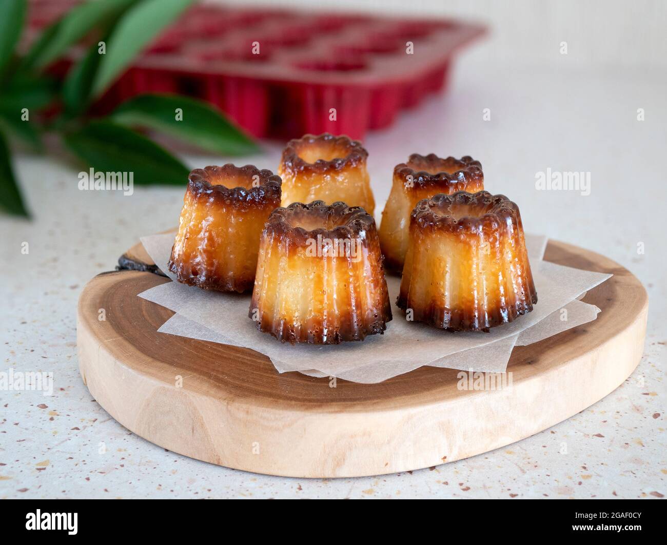 French caneles on a wooden board. Still life with a small fluted pastry ...
