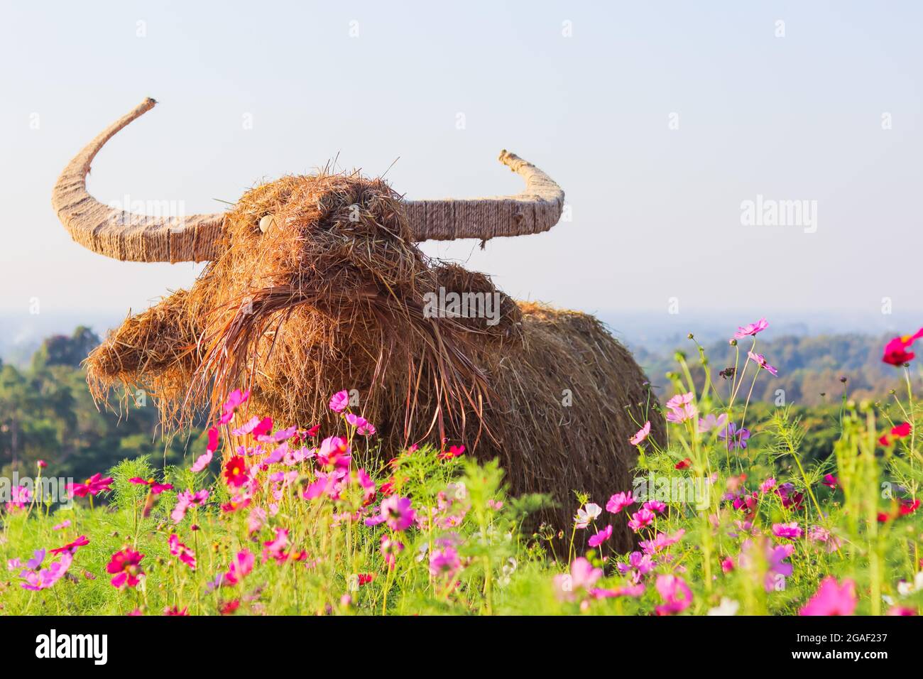 An animal shaped straw puppet is installed inside the flower garden to ...