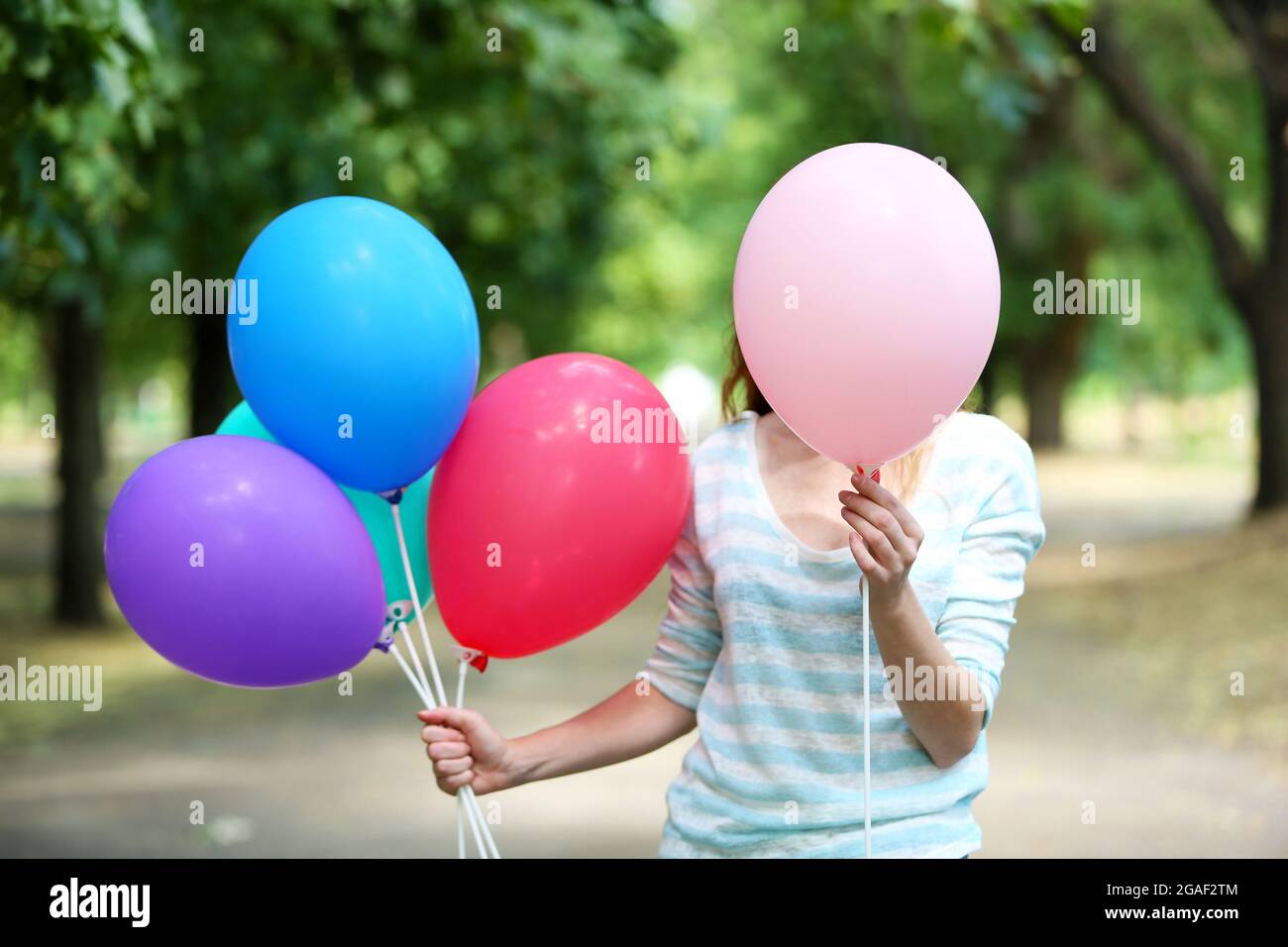 Girl with balloons hiding behind the balloon Stock Photo - Alamy