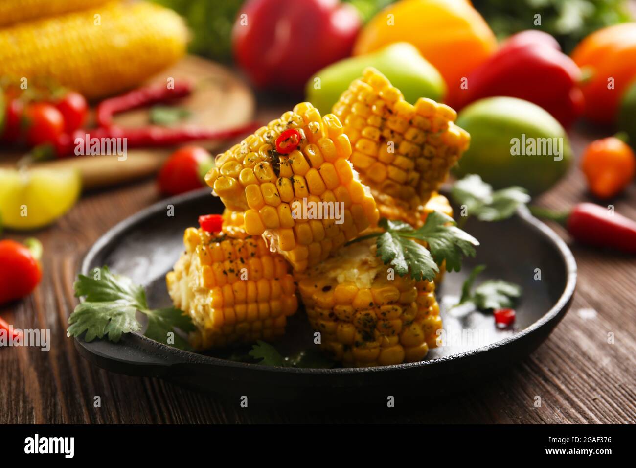 Tasty grilled corn and vegetables on black crockery Stock Photo - Alamy