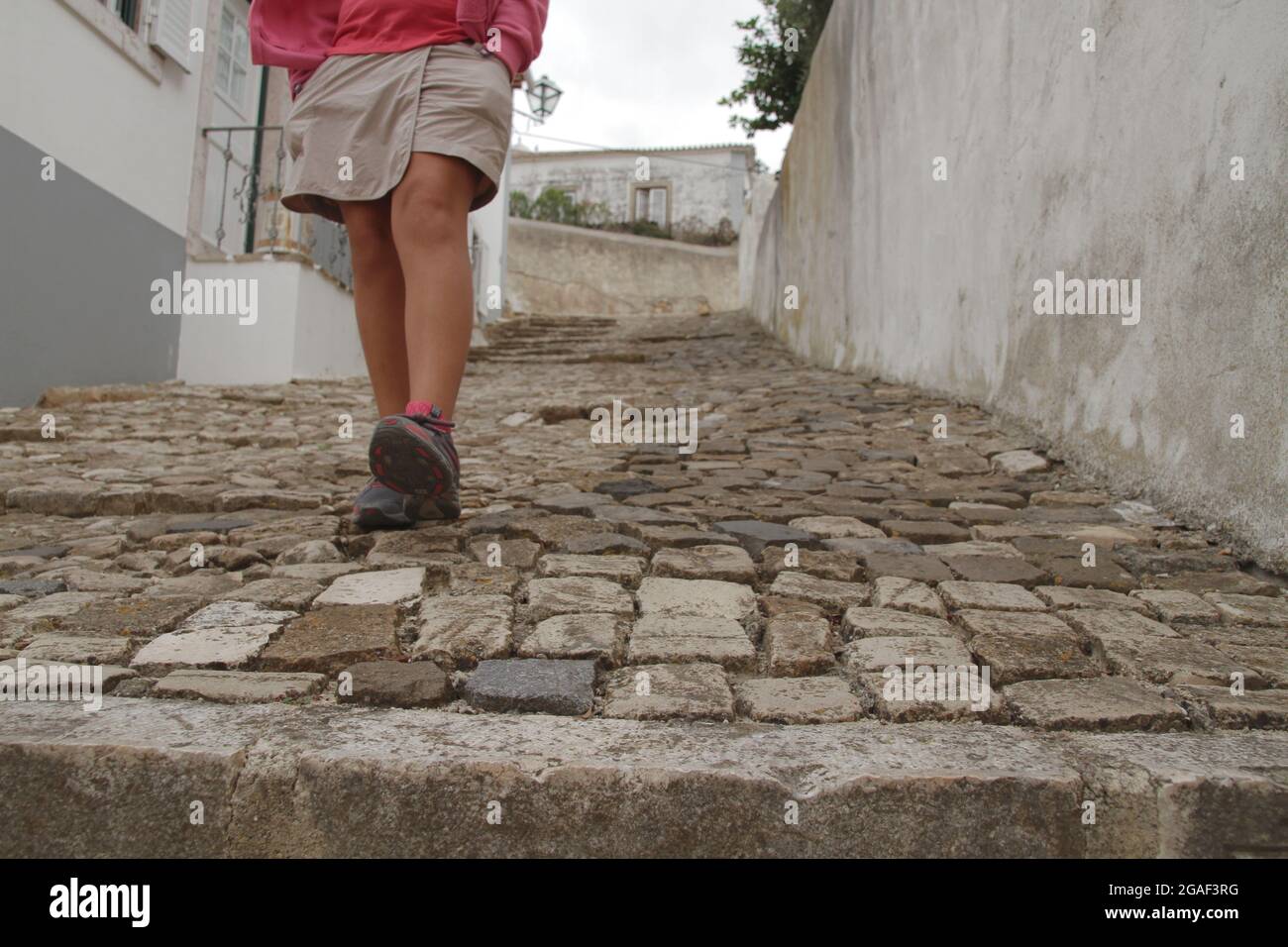 Legs of a tourist walking down the old paved path Stock Photo - Alamy