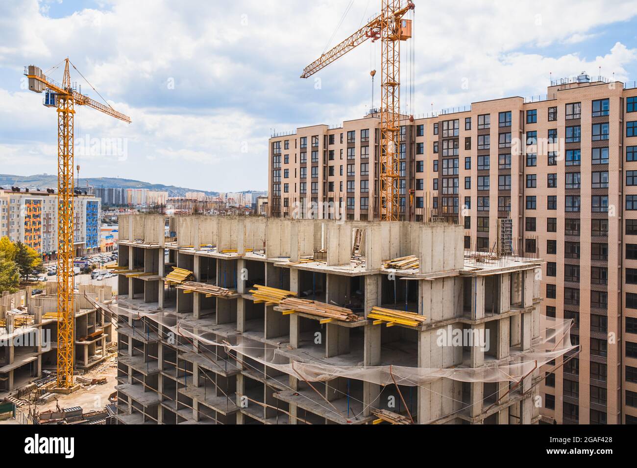 Modern construction site with cranes. Incomplete building construction ...