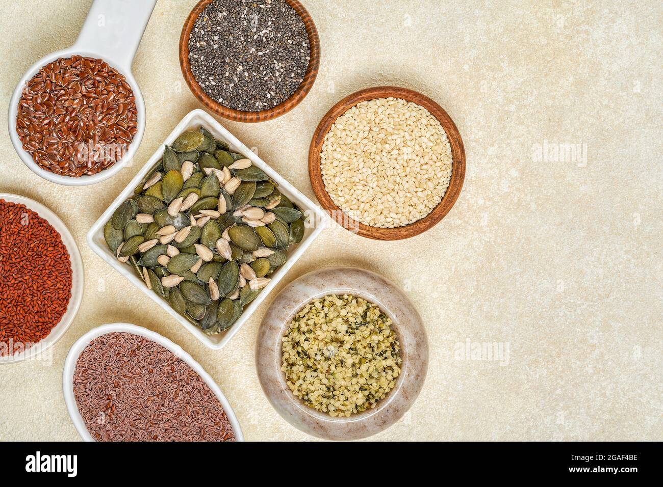 Various healthy seeds in bowls- flaxseed, sesame, pumpkin , sunflower ...