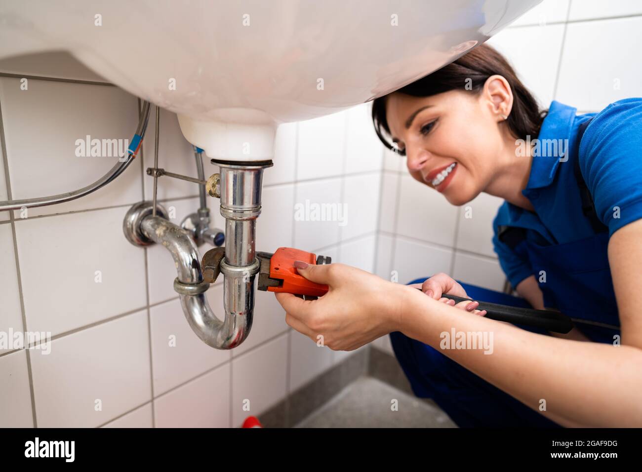 Young Plumber Fixing A Sink In Bathroom Stock Photo - Alamy
