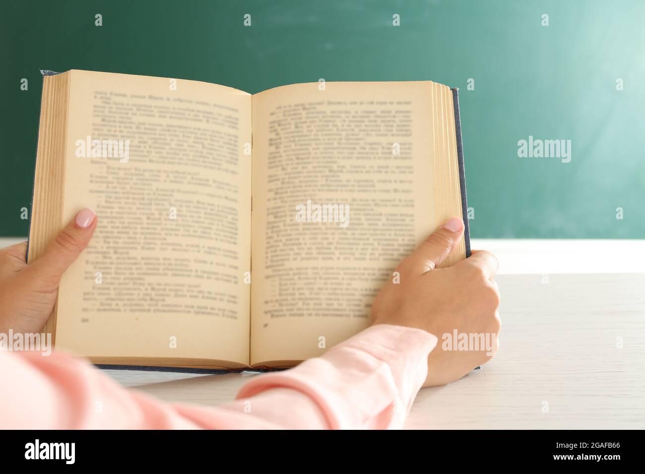 Women hands with book on blackboard background Stock Photo - Alamy