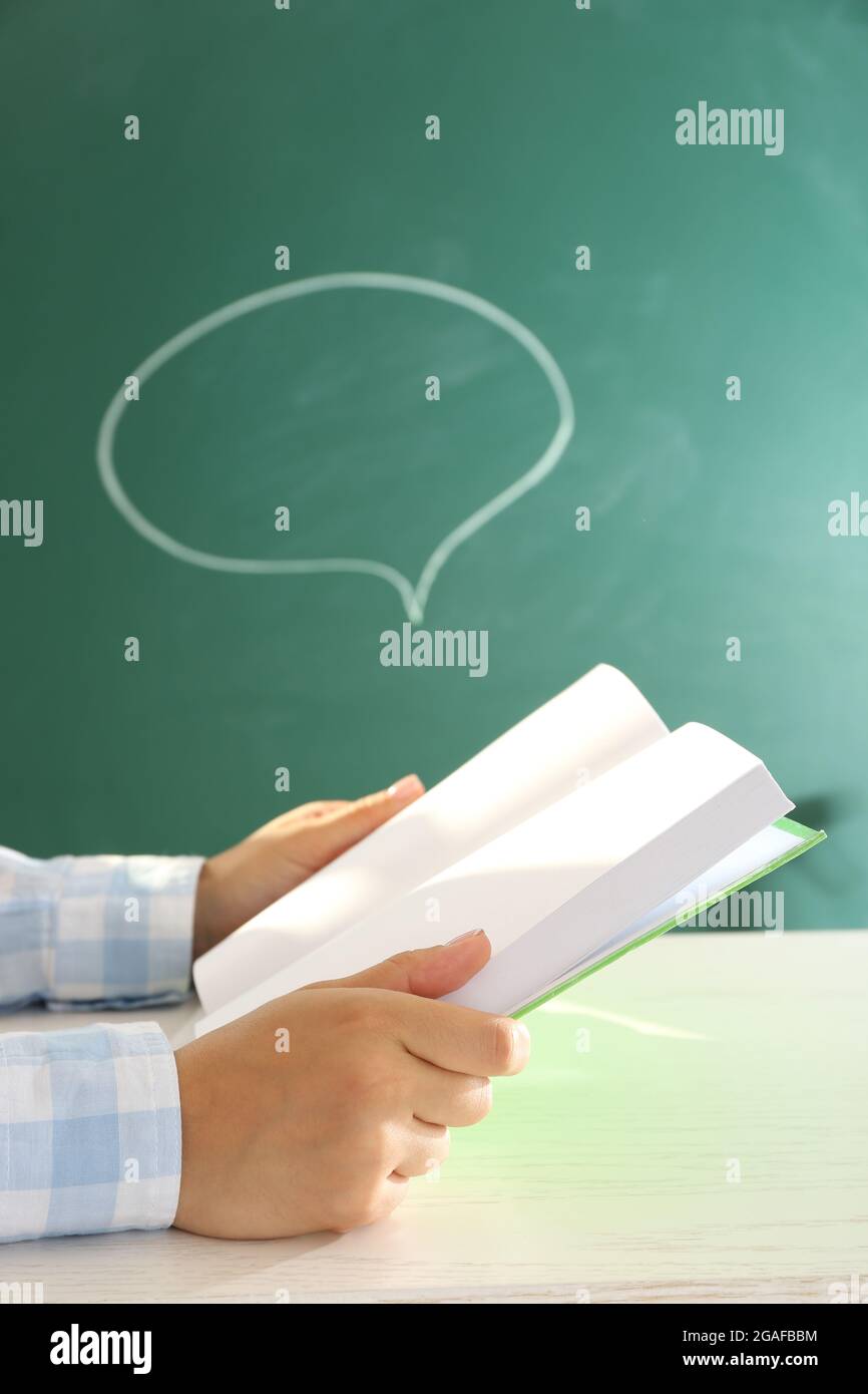 Women hands with book on blackboard background Stock Photo - Alamy