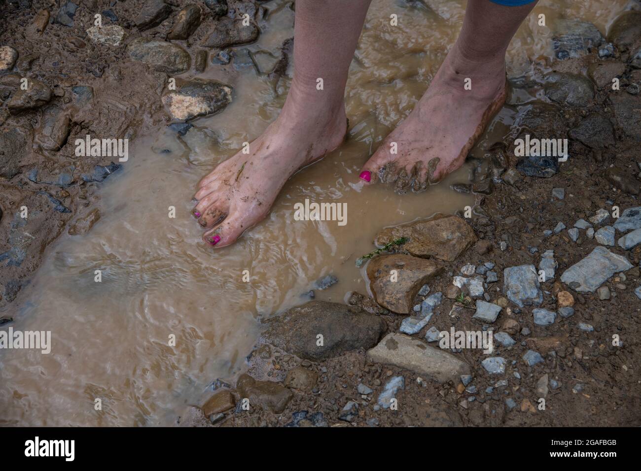 Feet in the water. People crossing muddy river in spring Stock Photo ...