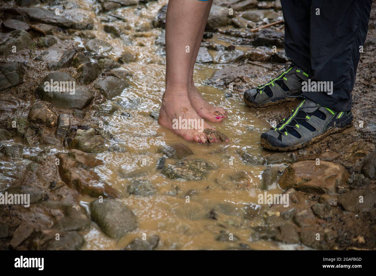 Feet in the water. People crossing muddy river in spring Stock Photo ...