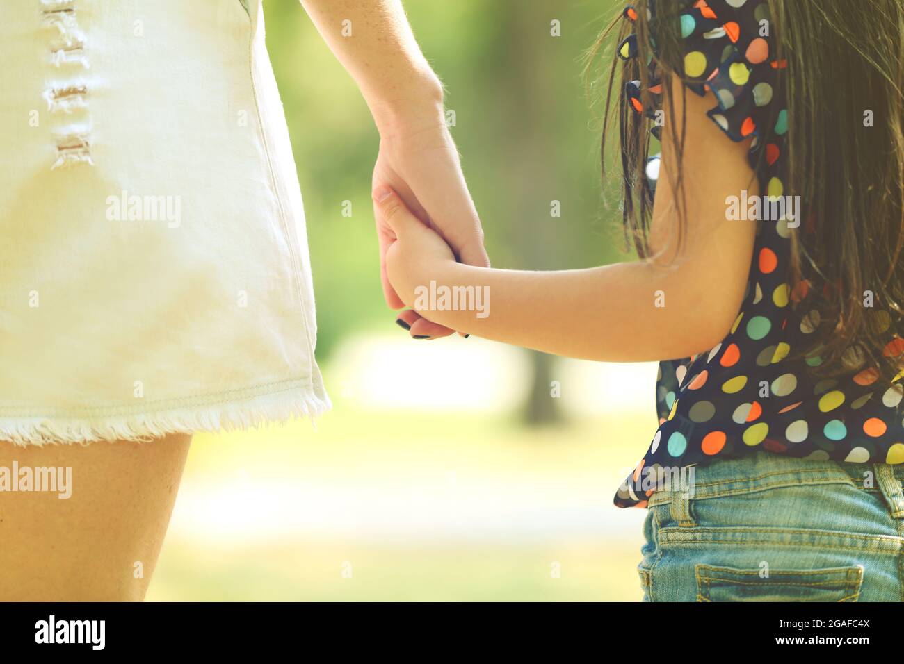 Mother's hand lead her child daughter outdoors, trust family concept ...