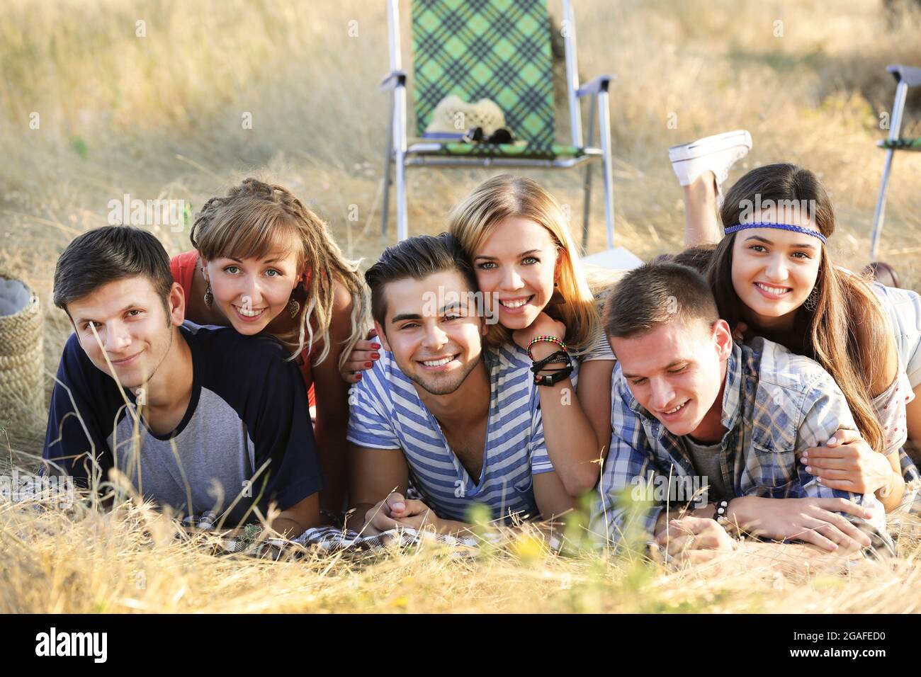 A group of happy smiling friends lying in the grass outdoors Stock ...