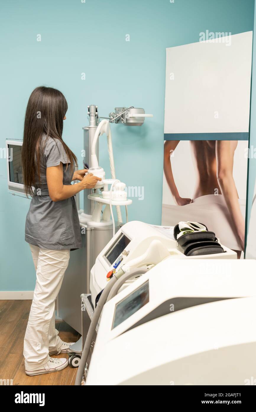 brunette woman preparing machines for laser beauty treatment Stock ...