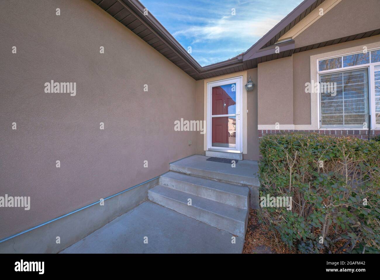 Concrete doorstep of a house with stairs and shrubs Stock Photo - Alamy