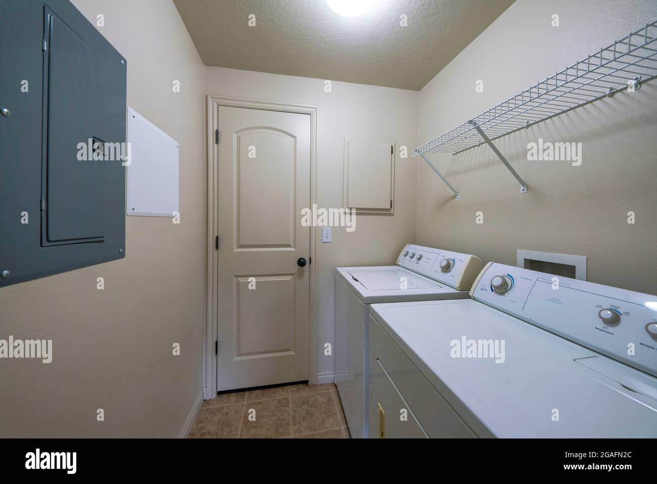 Laundry room interior with laundry machines and wall mounted white ...