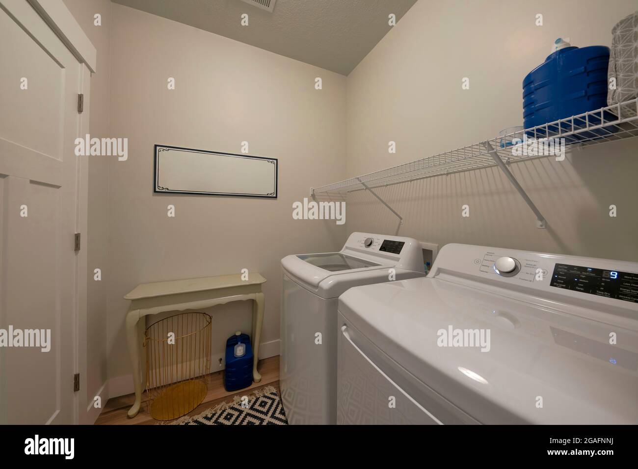 Laundry room interior with top load appliances and wire shelving unit ...
