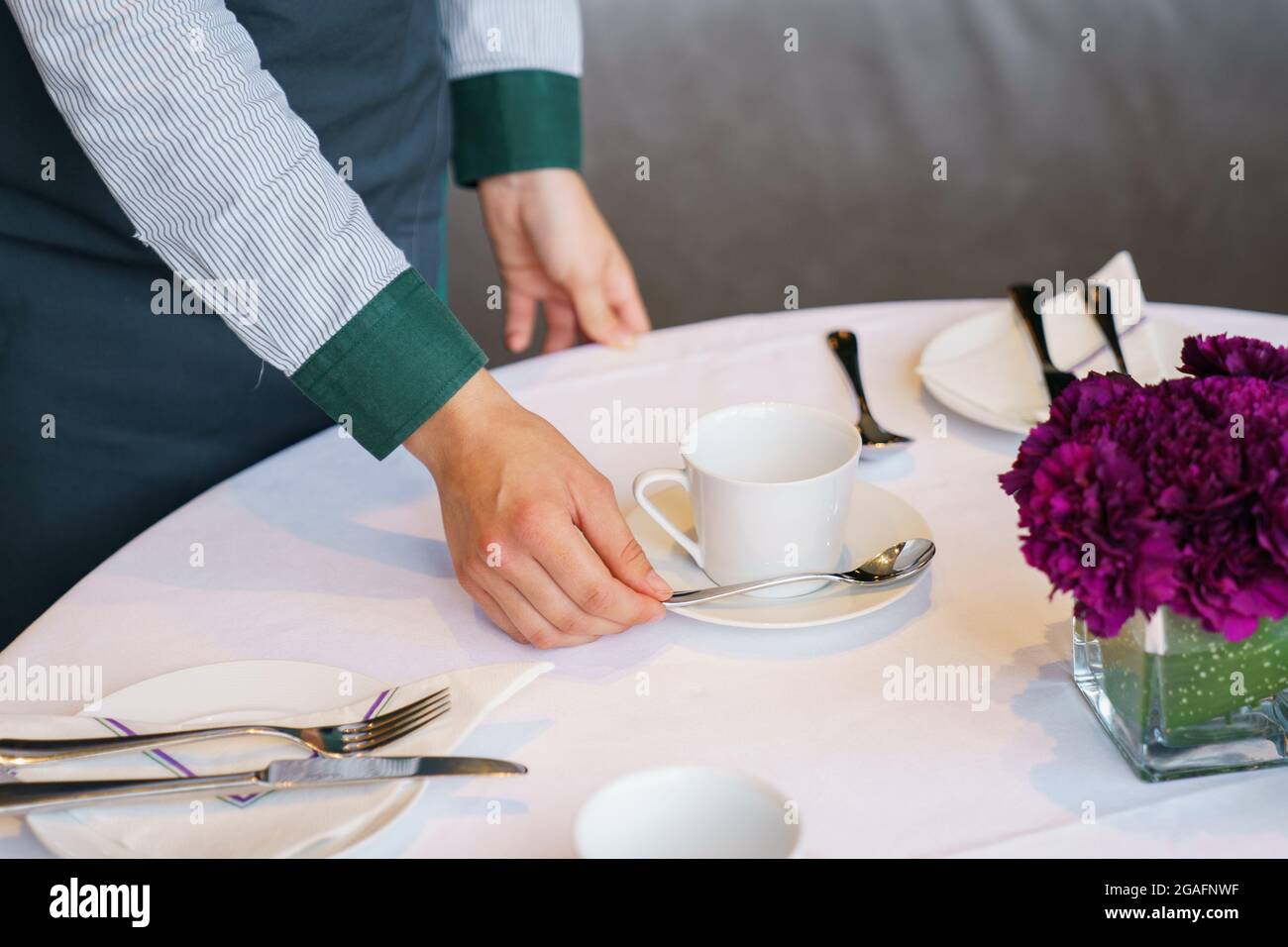 Waiting staff prepare a table in a restaurant Stock Photo - Alamy
