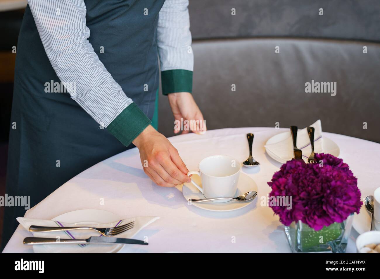 Waiting staff prepare a table in a restaurant Stock Photo - Alamy