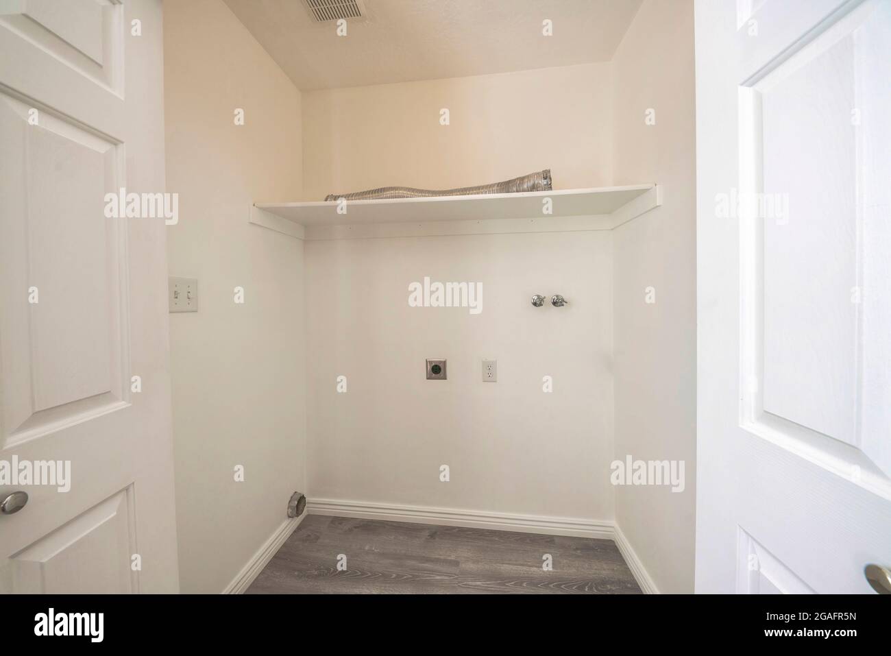 Empty laundry room interior with electrical socket and wall mounted ...