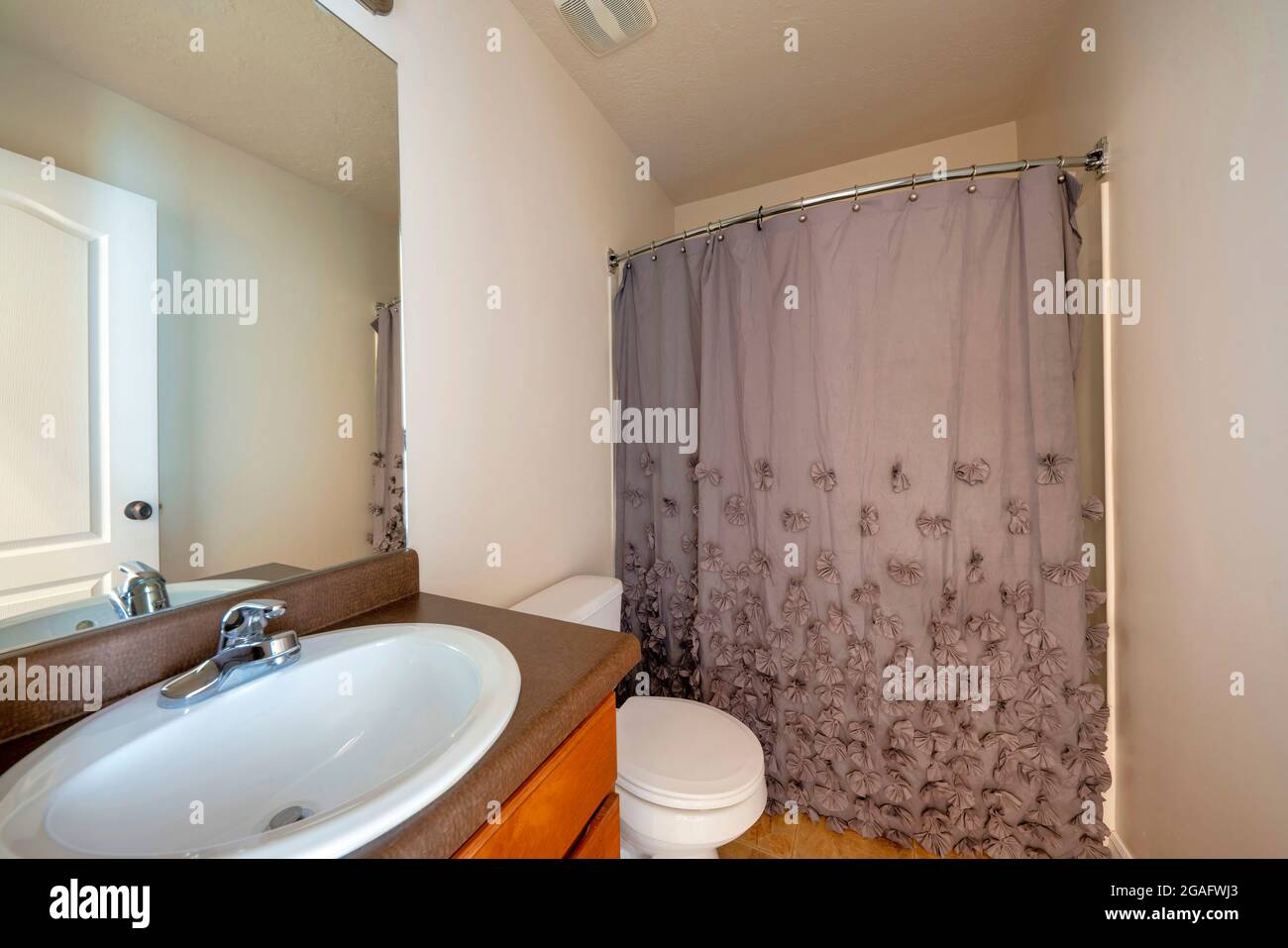Interior of a small bathroom with brown curtain with 3d design. There ...