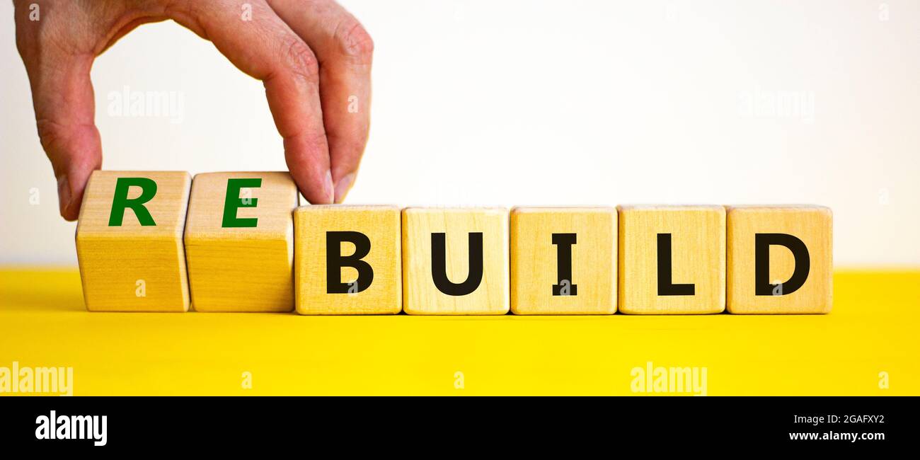Time to rebuild. Businessman turns wooden cubes and changes the word ...