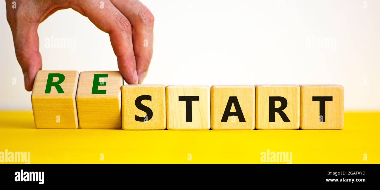 Start or restart symbol. Businessman turns wooden cubes and changes the ...
