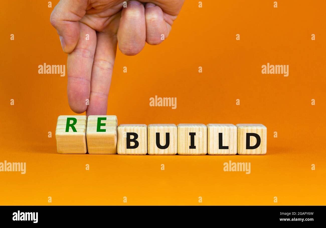 Time to rebuild. Businessman turns wooden cubes and changes the word ...