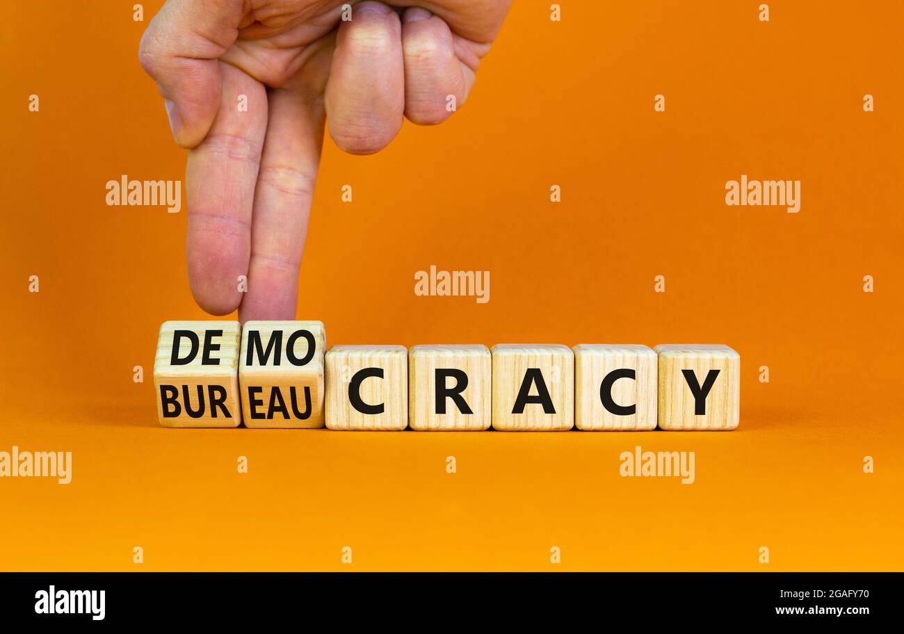 Democracy or bureaucracy symbol. Businessman turns wooden cubes and ...