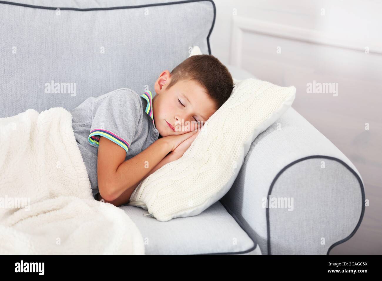 Little boy sleeping on sofa in room Stock Photo - Alamy