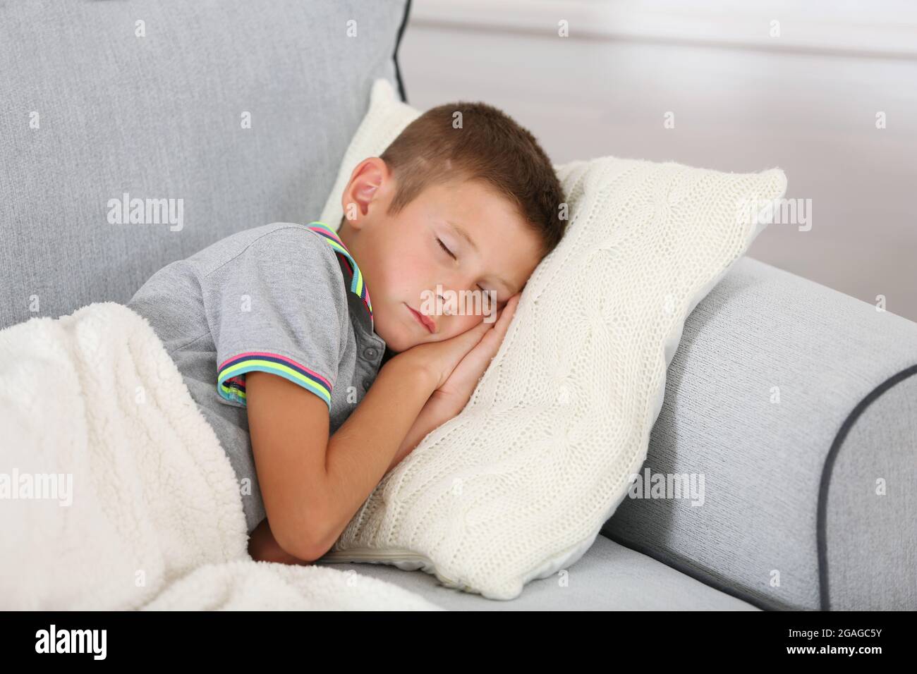Little boy sleeping on sofa in room Stock Photo - Alamy