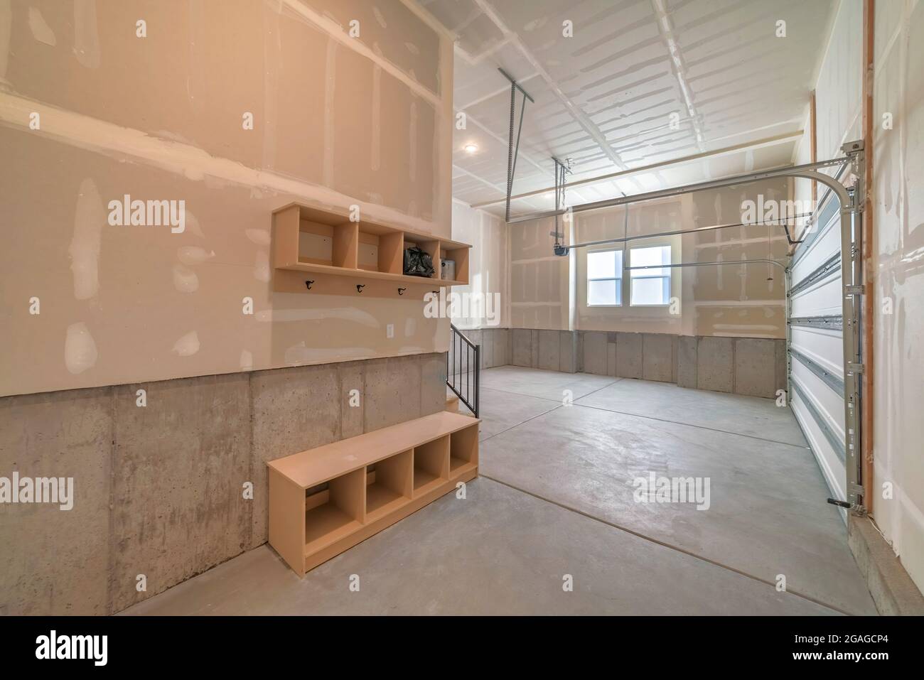 Unfinished garage door interior with mudroom and windows Stock Photo ...
