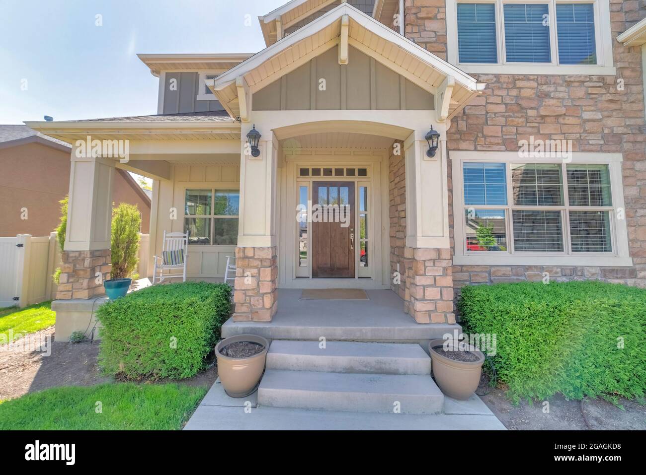 Facade of a house with traditional craftsman design and front shrubs ...