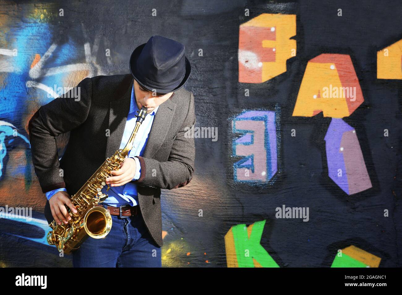 Saxophone player on graffiti wall background Stock Photo - Alamy