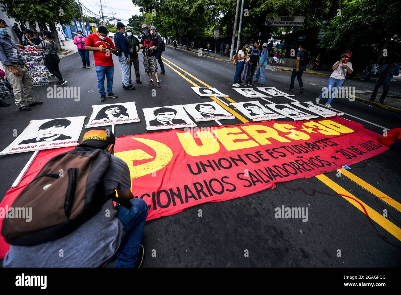 A demonstrator places a banner next to painted portraits of students ...